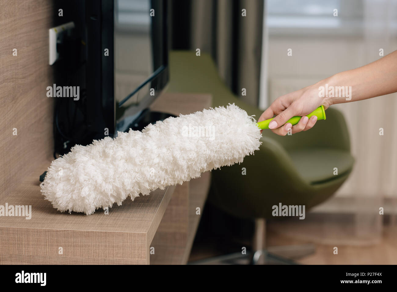 cropped shot of maid cleaning shelf with duster Stock Photo - Alamy