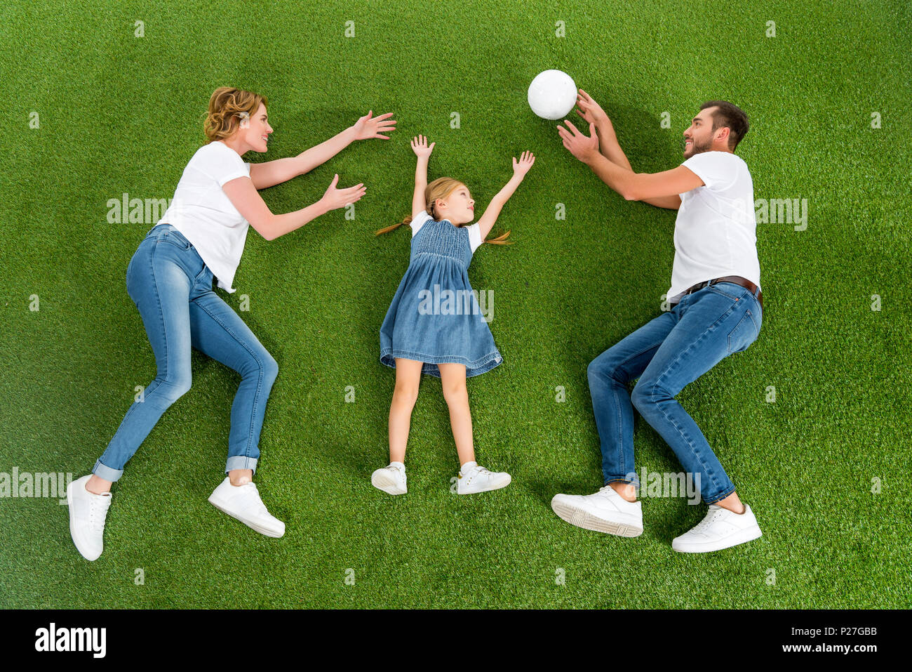 overhead view of family playing volleyball together on green lawn Stock ...