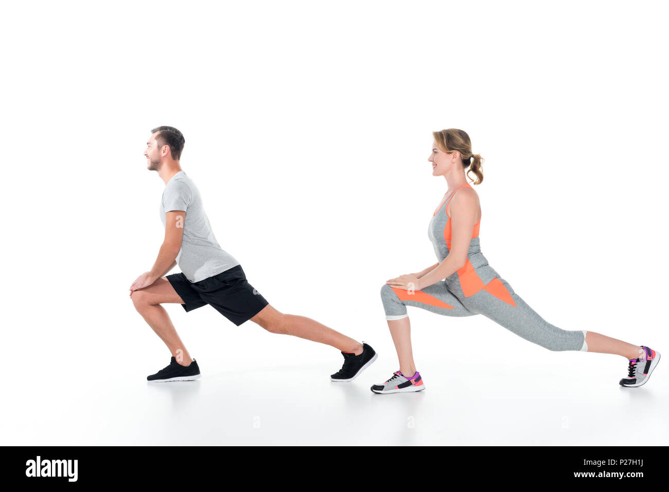 side view of sportive couple warming up before training isolated on ...