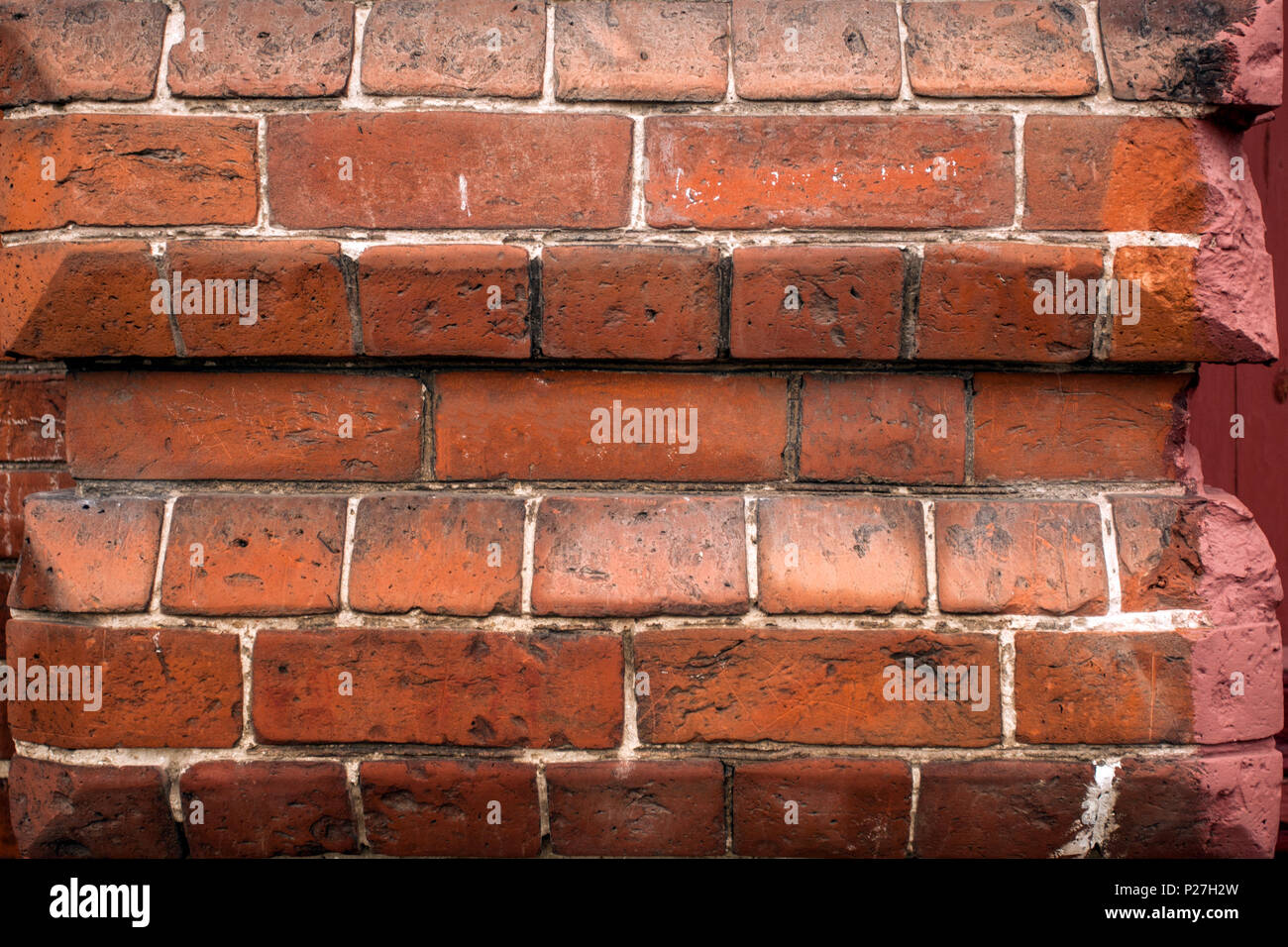 Red brick wall with stripes of different colors, texture grunge ...