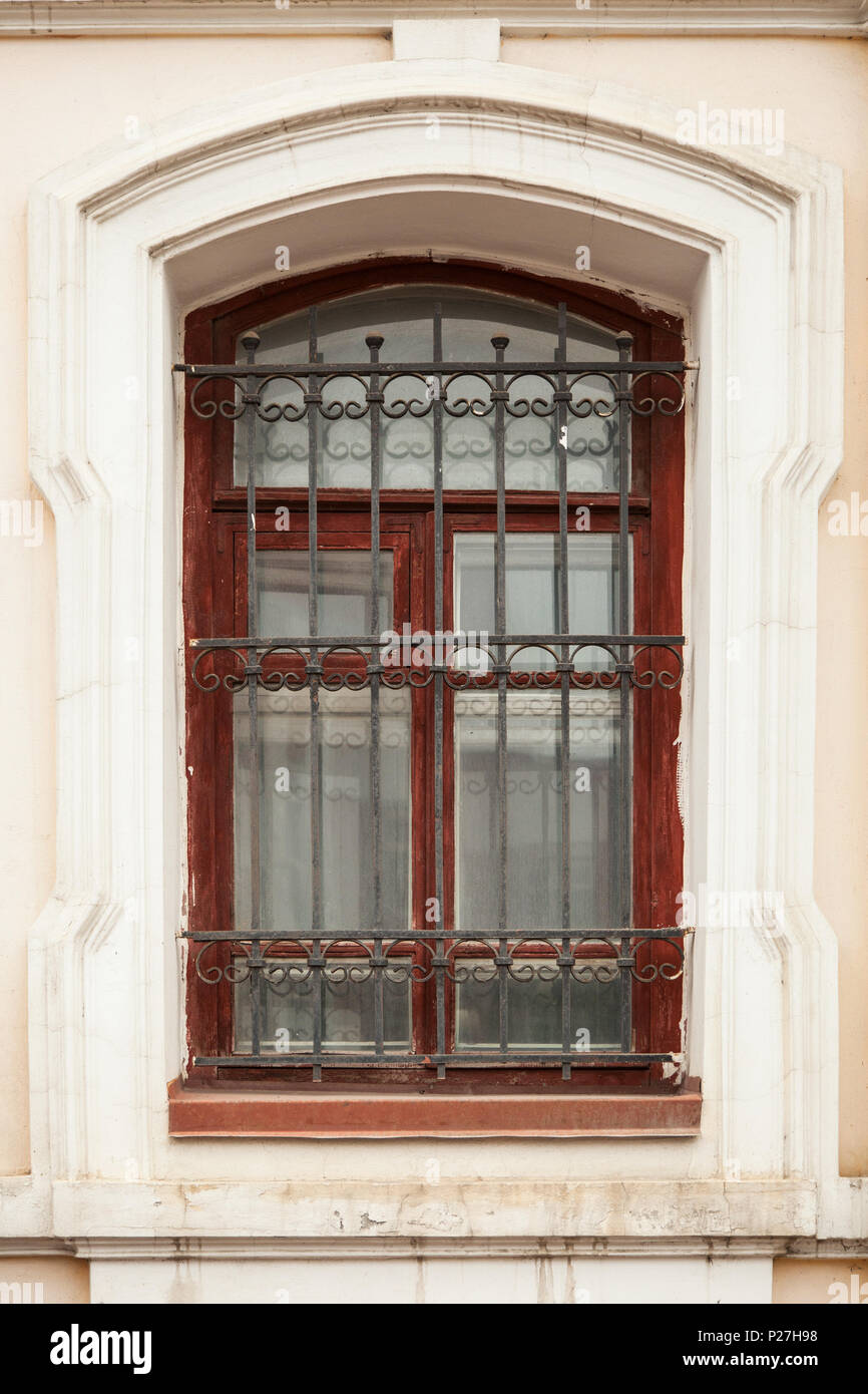 Close-up of an old wooden window with divided grilles in an old white ...