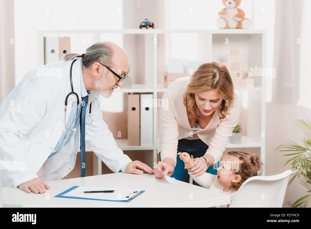 mother and crying little daughter at doctors reception in clinic Stock ...