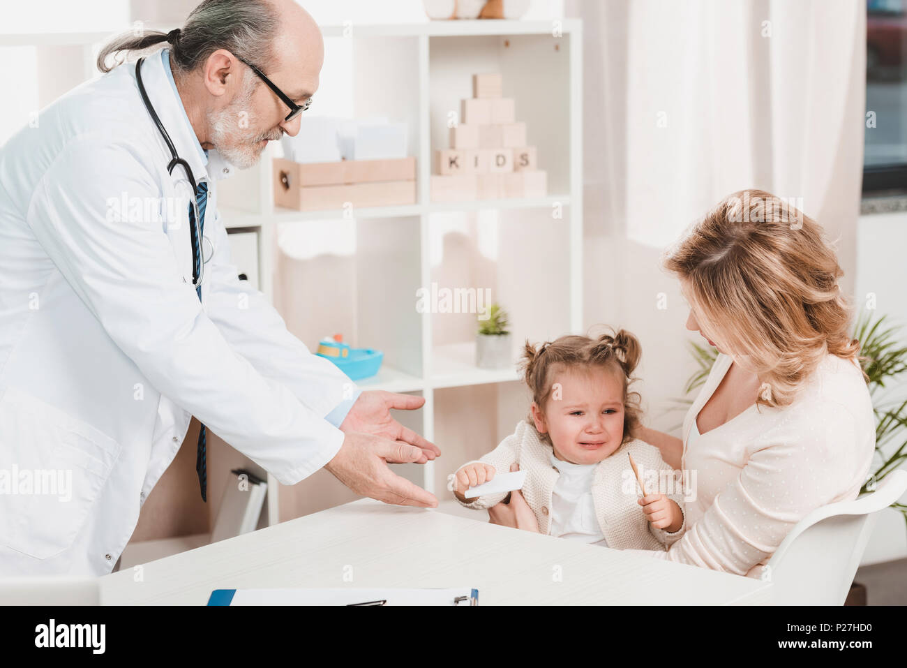 mother and crying little daughter at doctors reception in clinic Stock ...