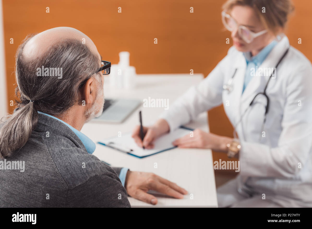 selective focus of senior patient at the doctors reception in clinic ...