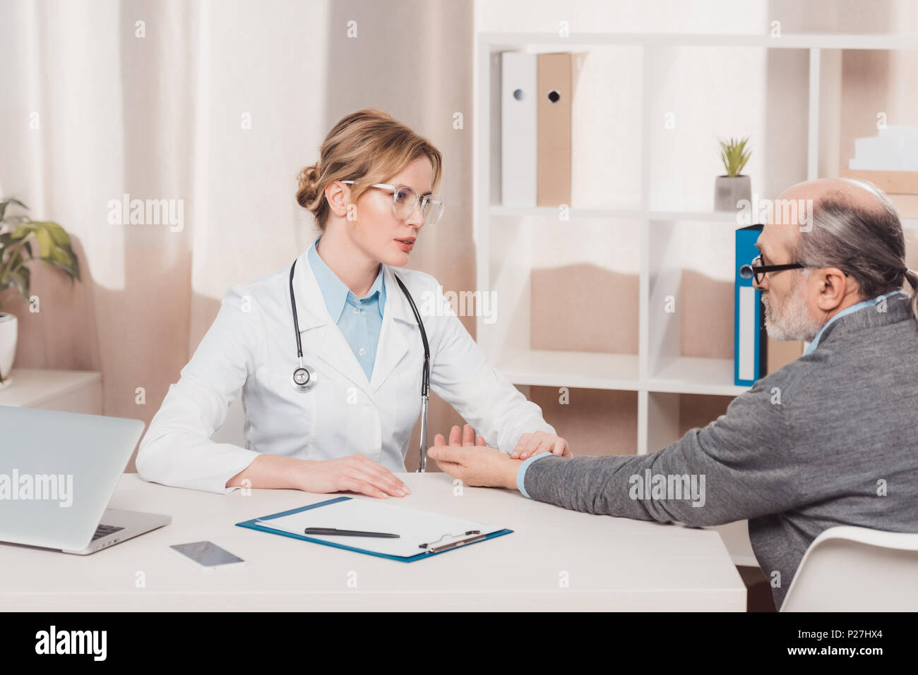 Doctor checking patients pulse hi-res stock photography and images - Alamy