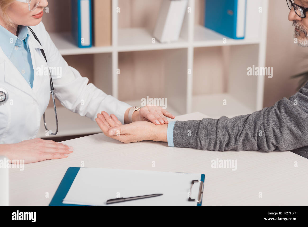 partial view of female doctor checking patients pulse in clinic Stock ...