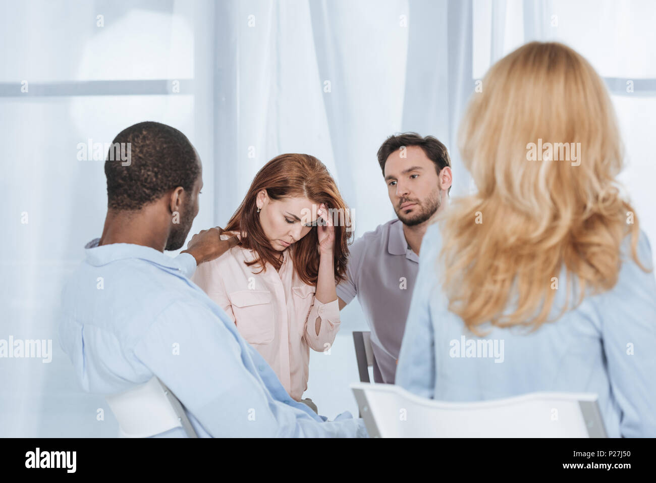 multiethnic middle aged people supporting depressed woman during ...