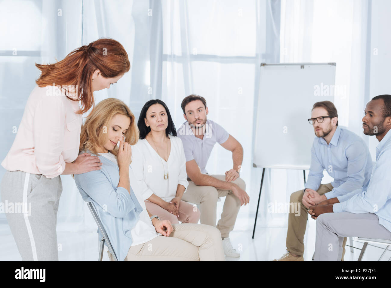 Psychotherapist Supporting Middle Aged Woman During Group Therapy Stock