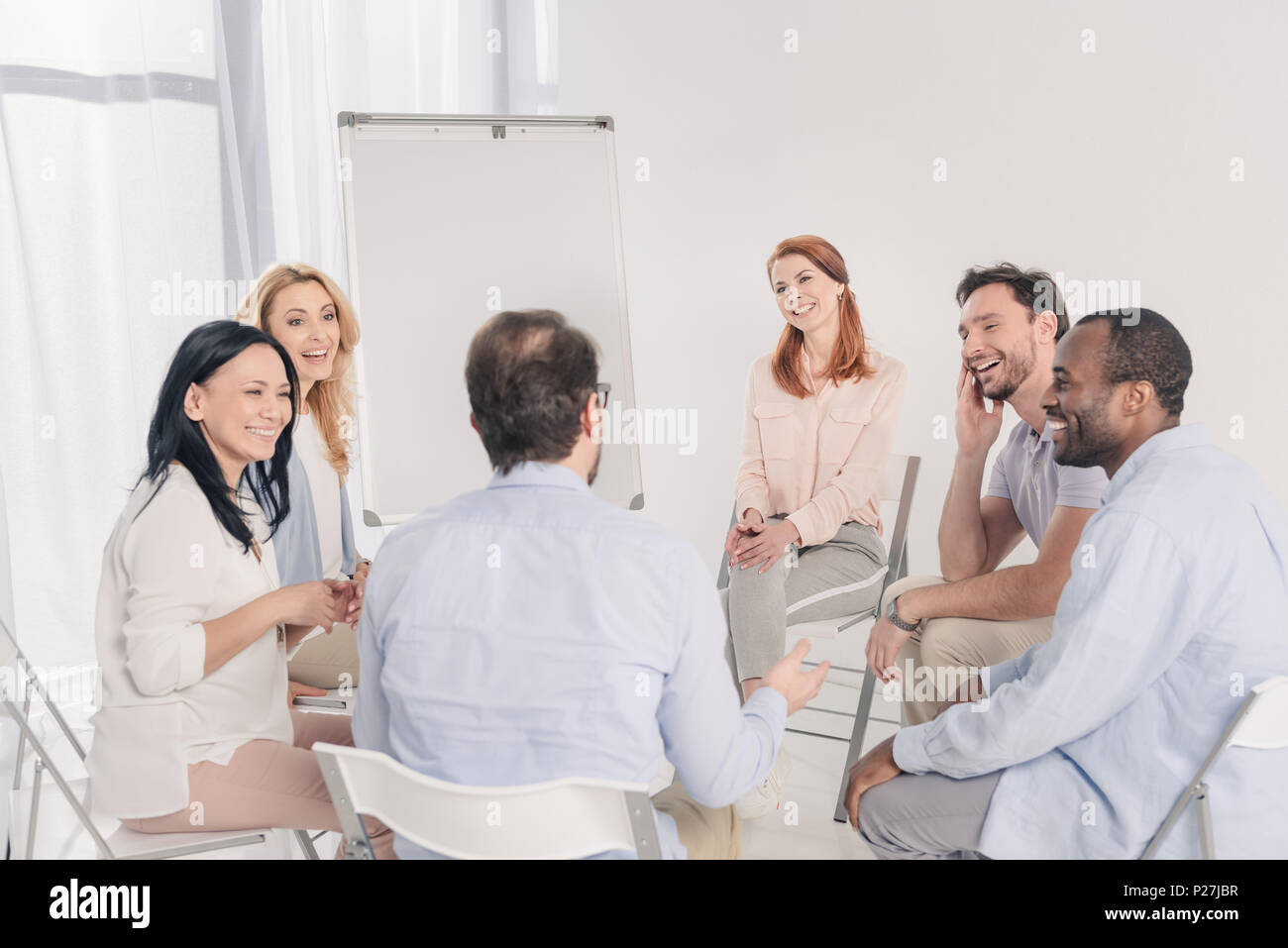 multiethnic middle aged people talking and smiling during group therapy ...