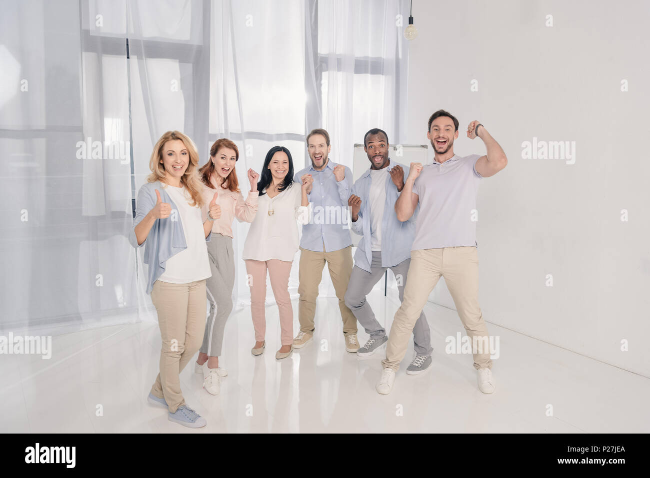 happy multiethnic mid adult people triumphing and smiling at camera ...