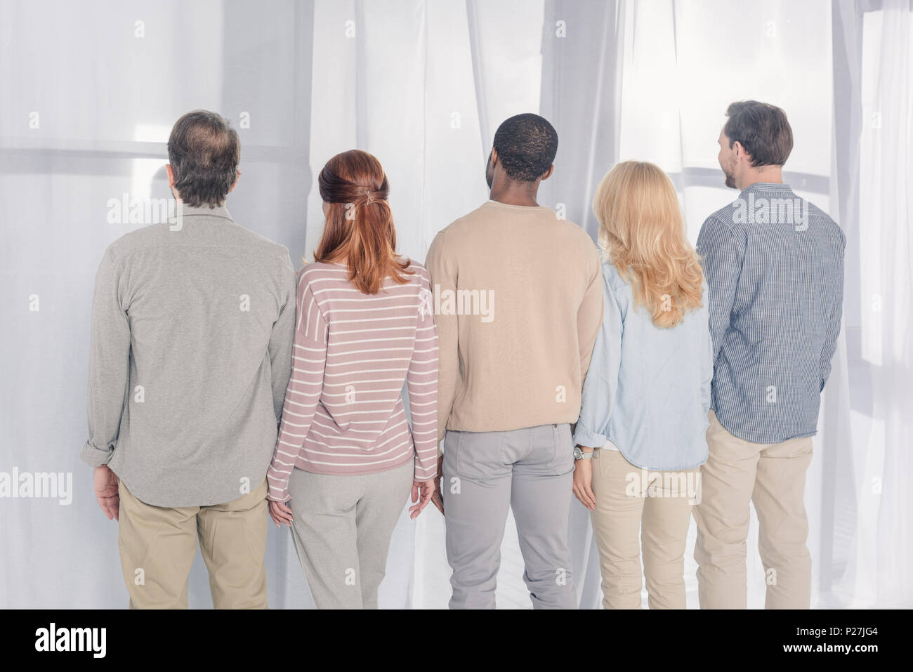 back view of multiethnic people standing together during group therapy ...