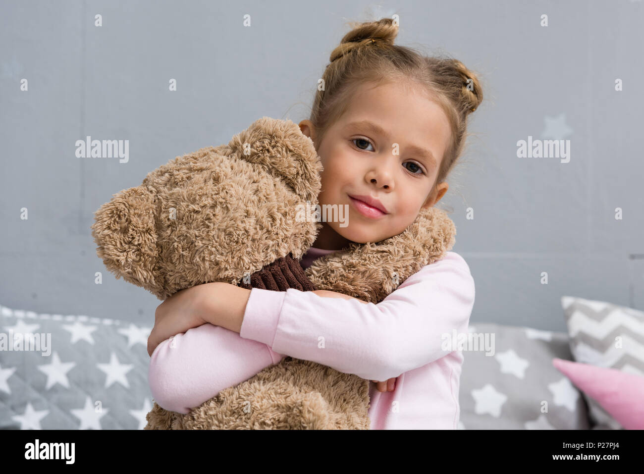 adorable little kid embracing her teddy bear and looking at camera ...