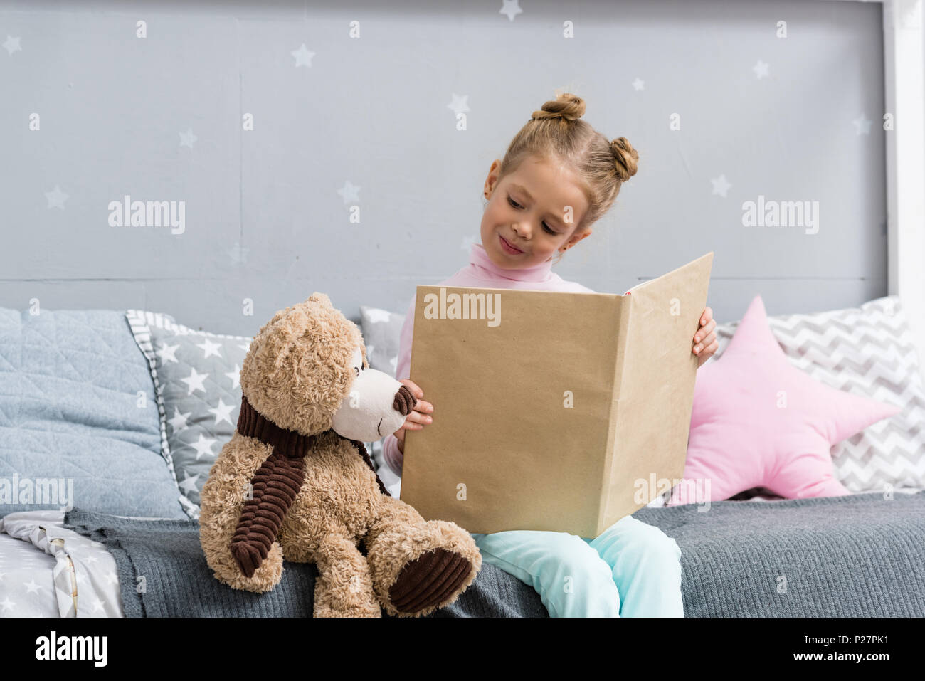 adorable little kid reading book in bed with teddy bear Stock Photo - Alamy