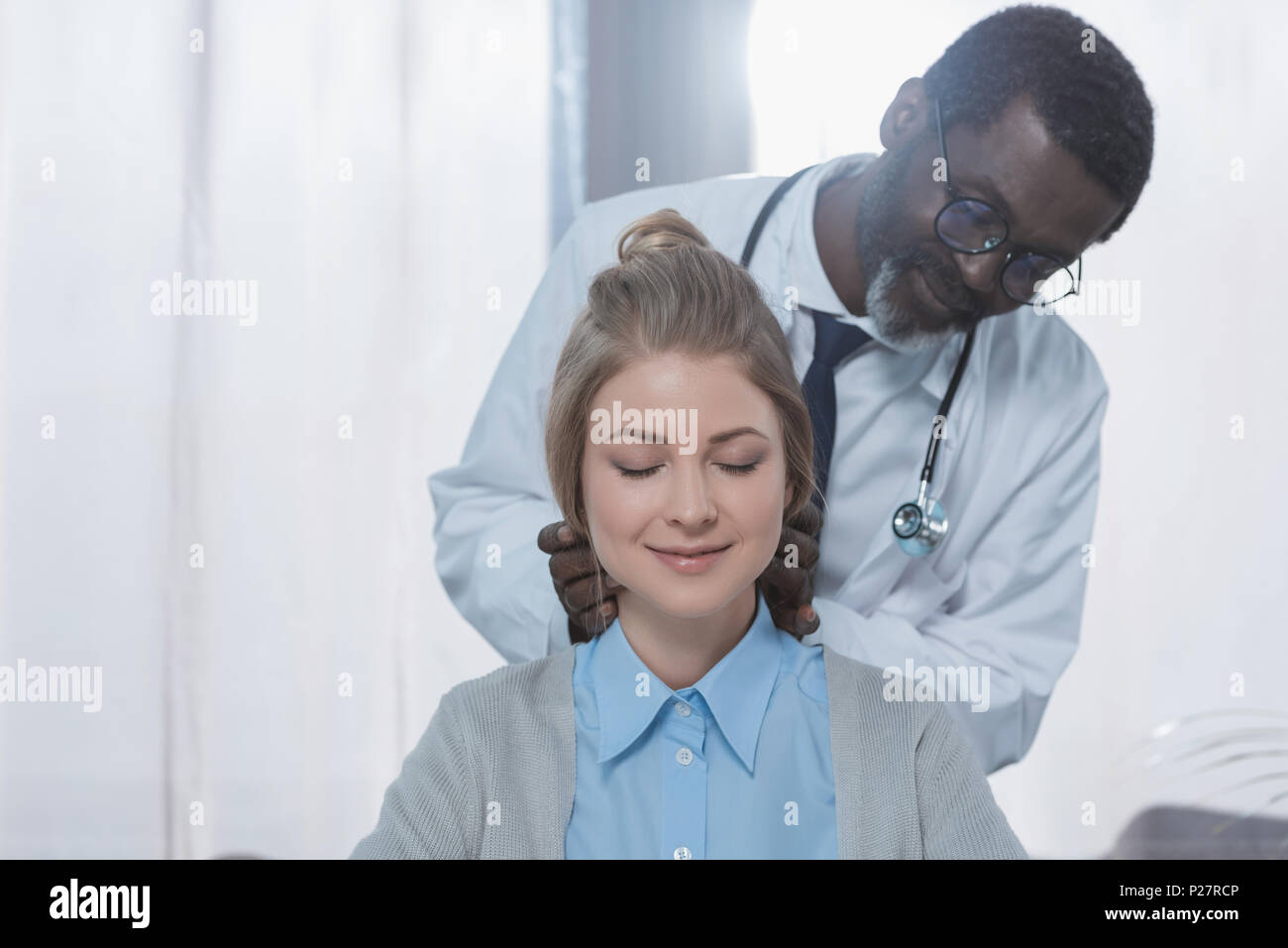 african american Doctor palpating lymph nodes of smiling female patient ...