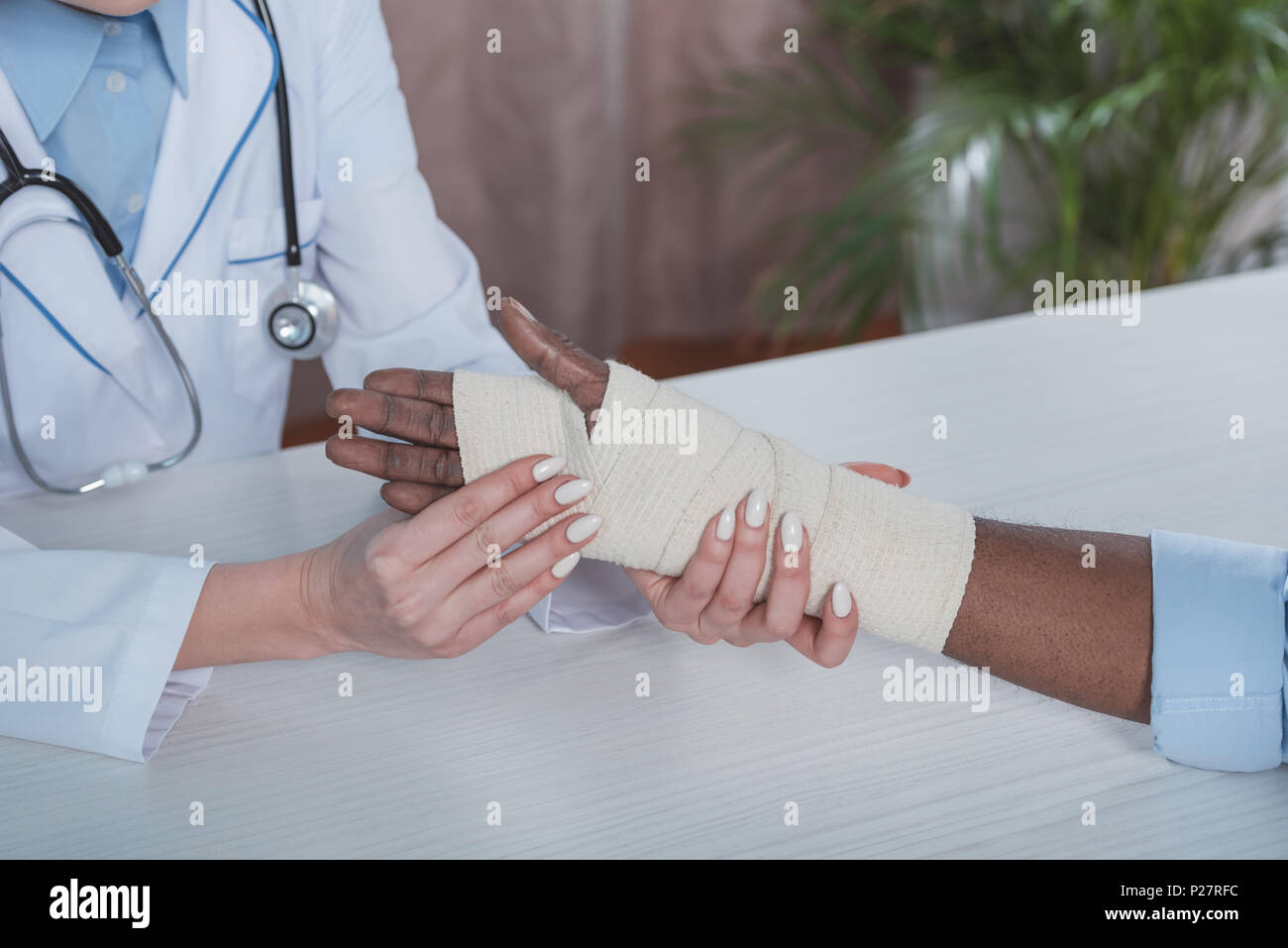 Female doctor bandaging hands hi-res stock photography and images - Alamy