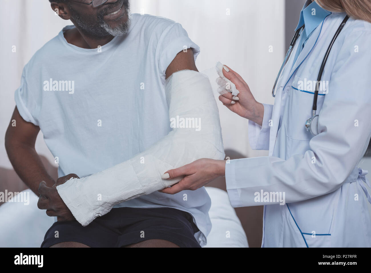 Cropped image of doctor bandaging african american patient hand with ...