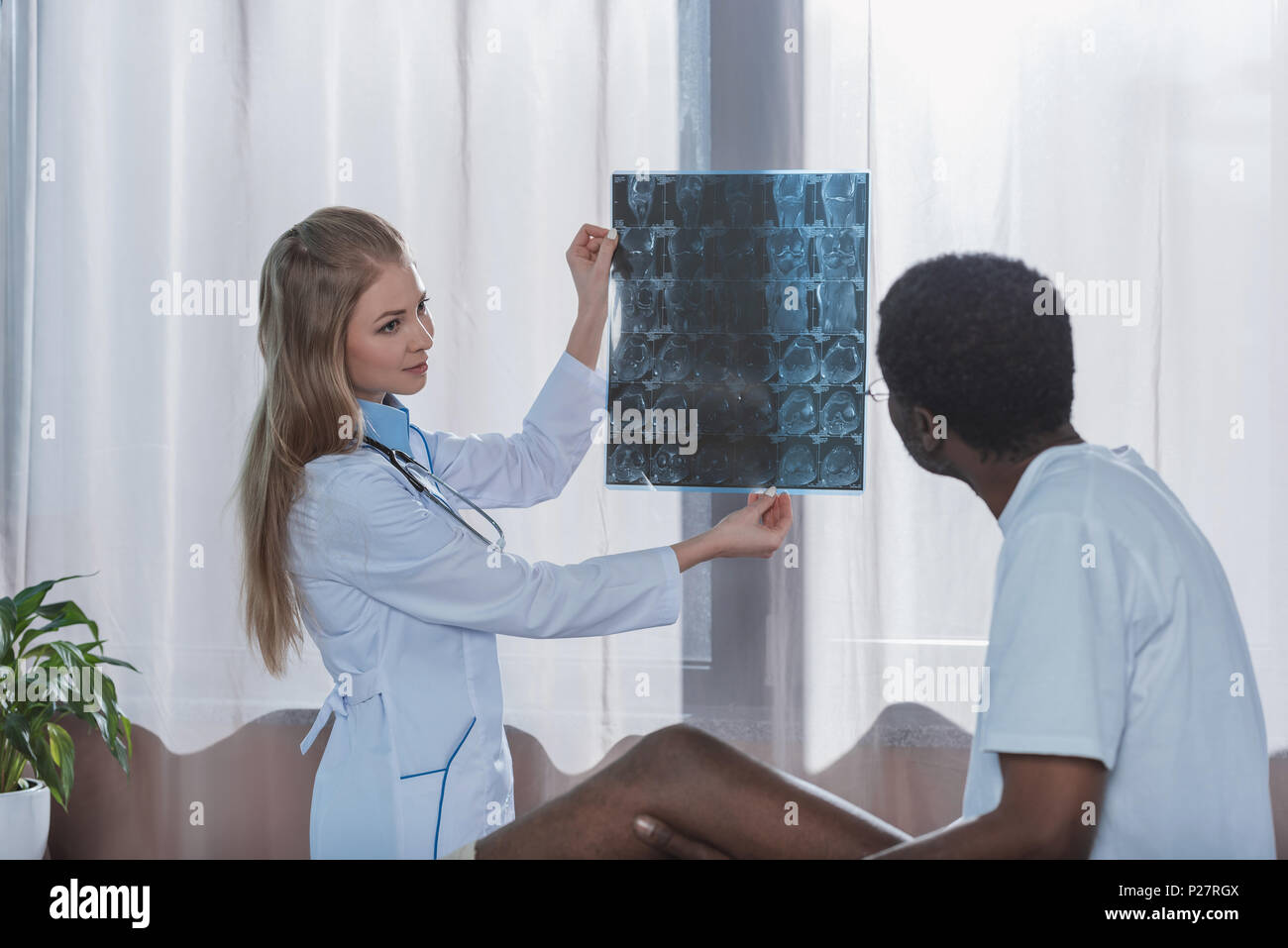 Doctor showing x-ray to african american patient in the clinic Stock ...
