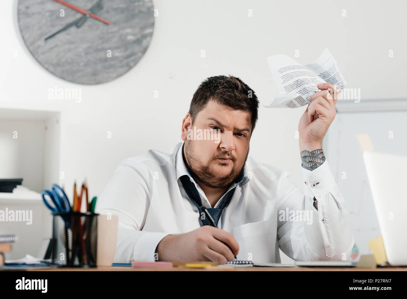 overweight businessman writing and doing paperwork in office Stock ...