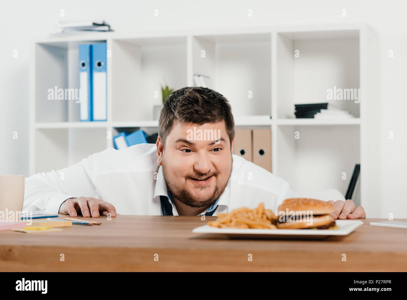 Overweight man eating in office hi-res stock photography and images - Alamy