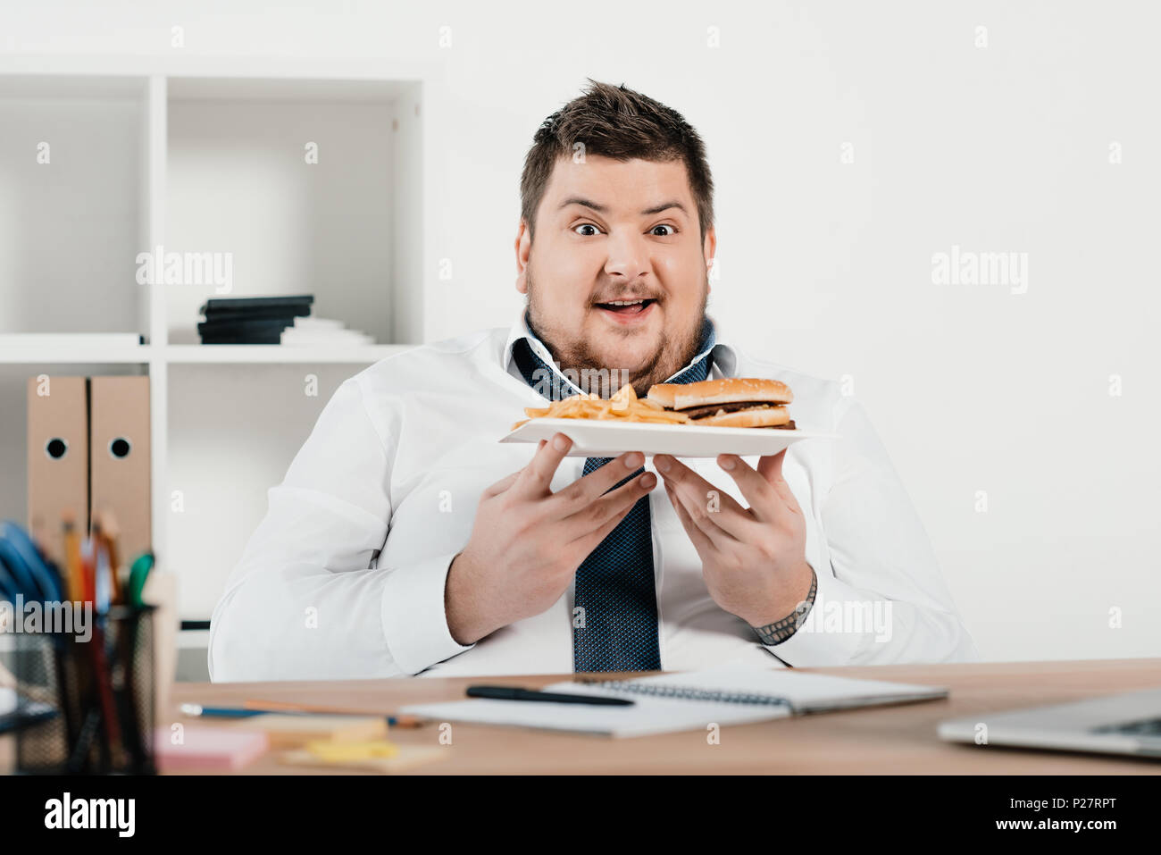 Overweight man eating in office hi-res stock photography and images - Alamy
