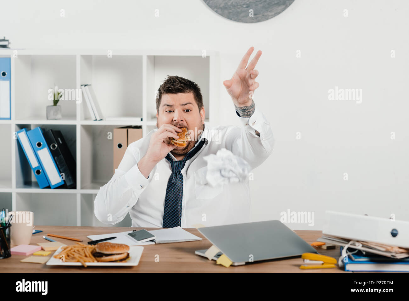 Overweight man eating in office hi-res stock photography and images - Alamy