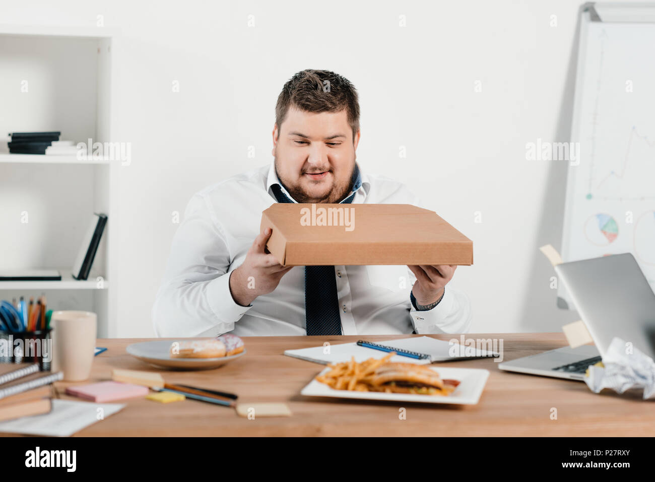 overweight businessman eating pizza at workplace Stock Photo - Alamy