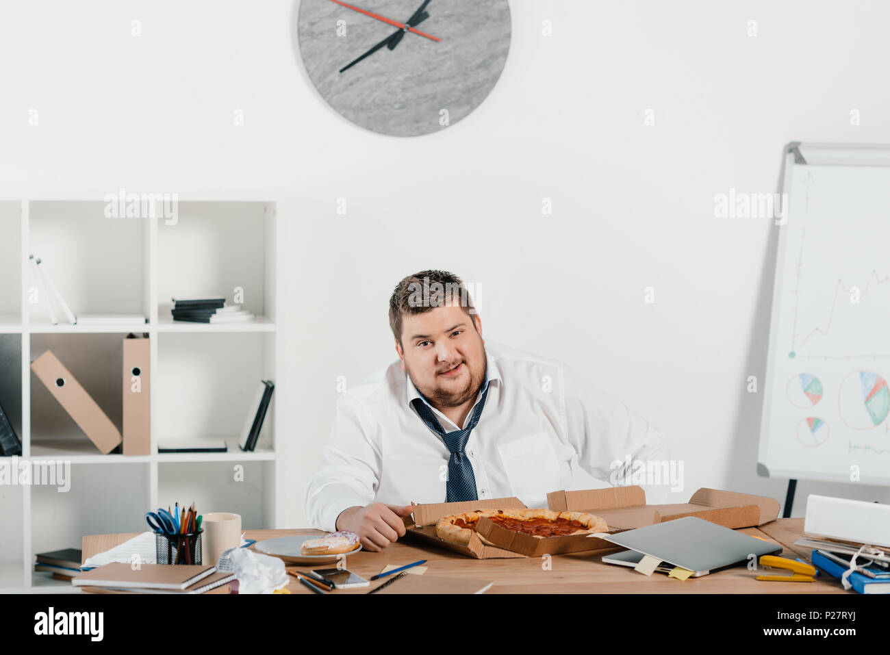 Overweight man eating in office hi-res stock photography and images - Alamy