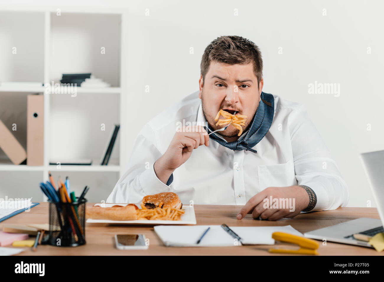 overweight businessman eating junk food at workplace Stock Photo - Alamy