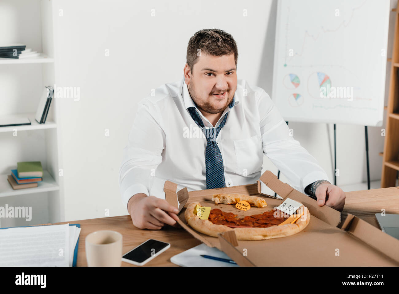 Overweight man eating in office hi-res stock photography and images - Alamy