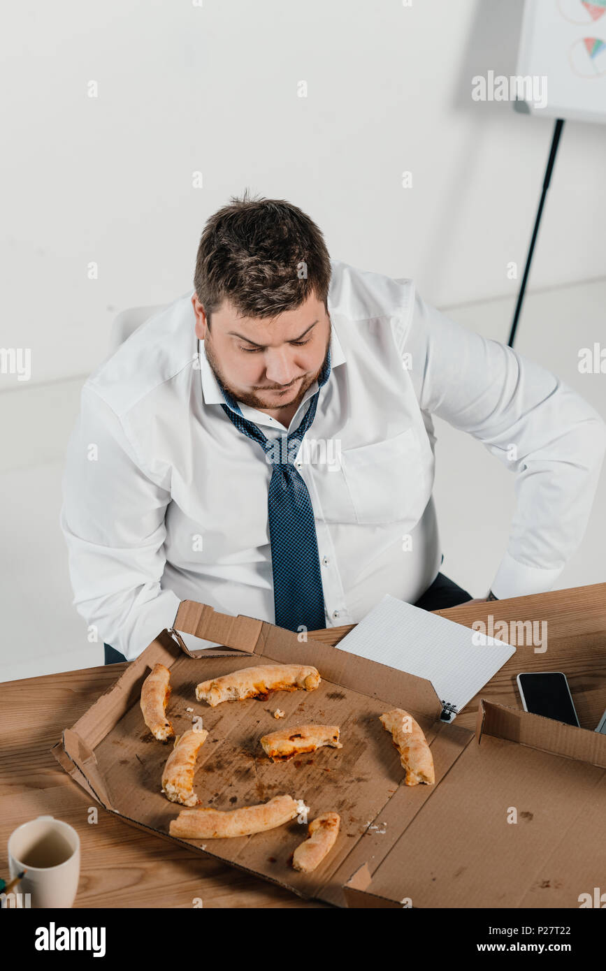 Overweight man eating in office hi-res stock photography and images - Alamy