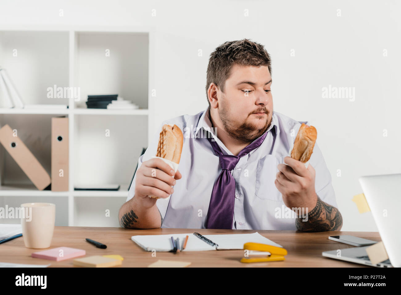 Overweight man eating in office hi-res stock photography and images - Alamy