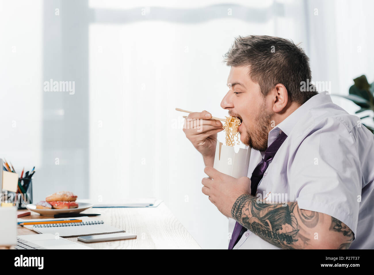 Overweight man eating in office hi-res stock photography and images - Alamy