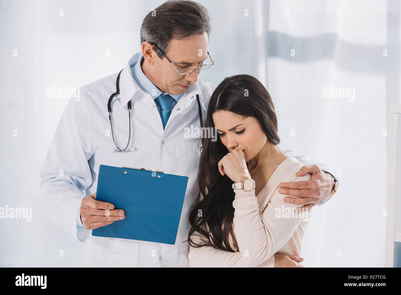 male doctor hugging upset female patient Stock Photo - Alamy