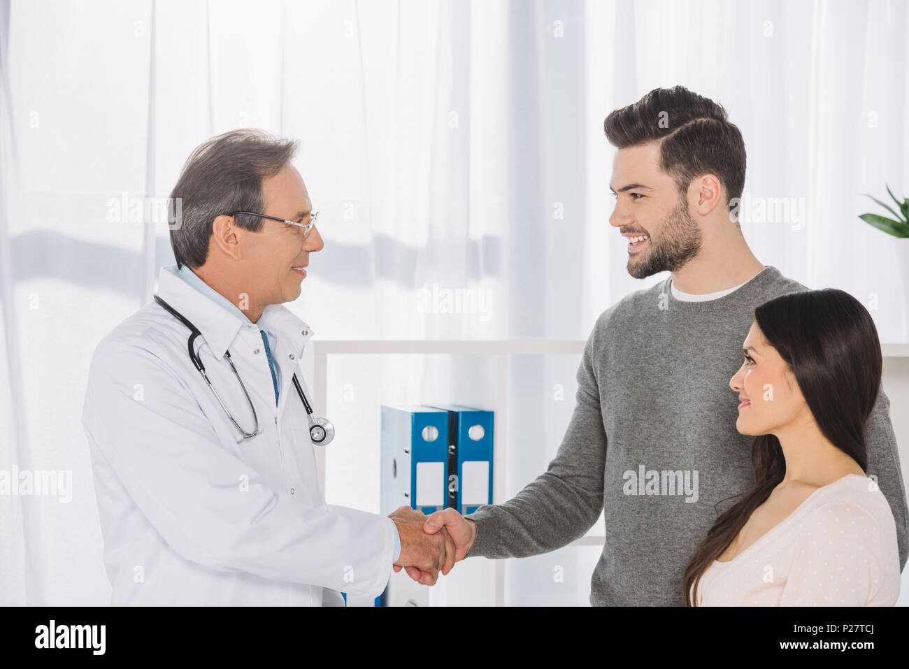 doctor and smiling patient shaking hands Stock Photo - Alamy