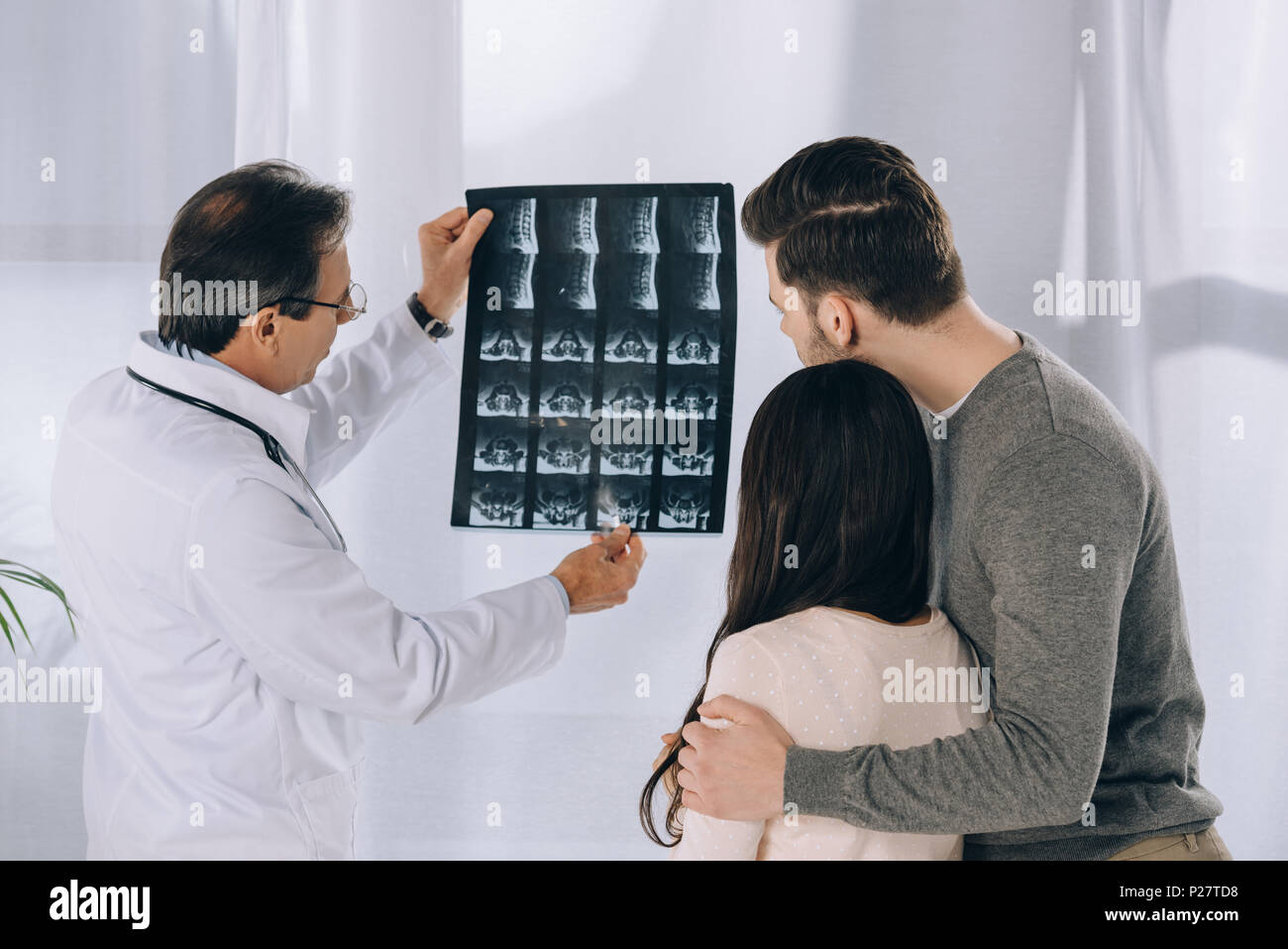 doctor showing couple x-ray photo Stock Photo - Alamy