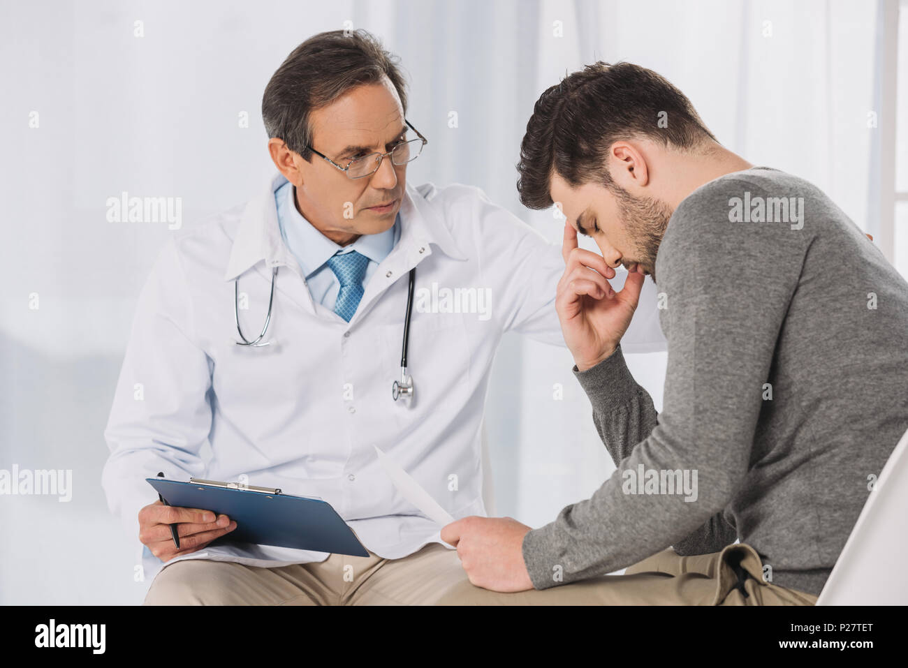 doctor putting hand on upset patient shoulder Stock Photo - Alamy