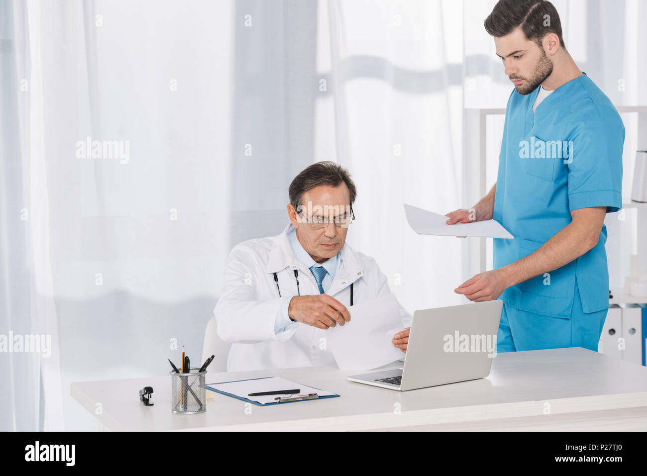 doctor reading documents and giving them to nurse Stock Photo - Alamy