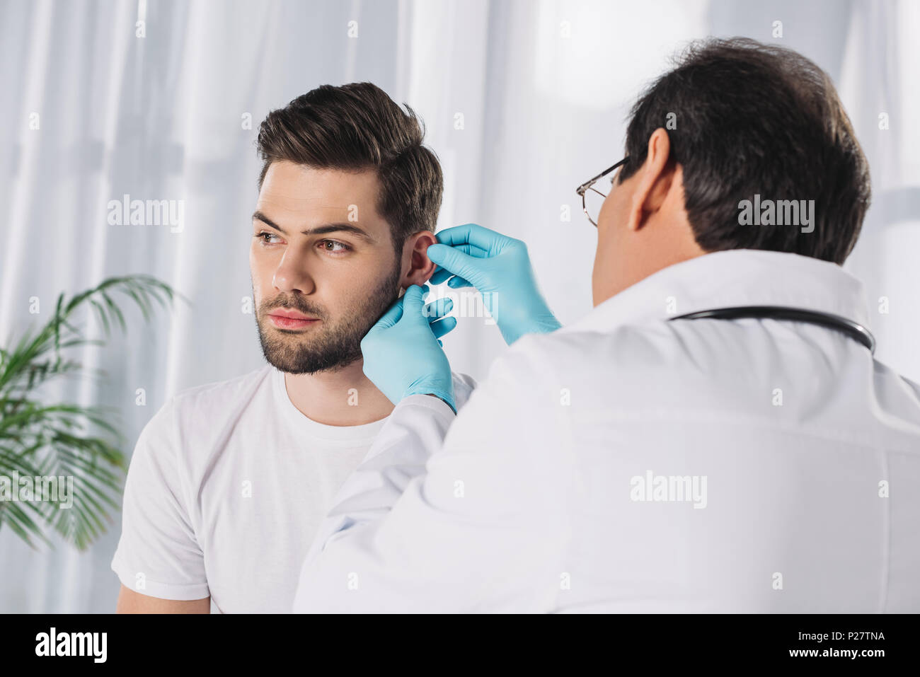 doctor examining male patient ear Stock Photo - Alamy
