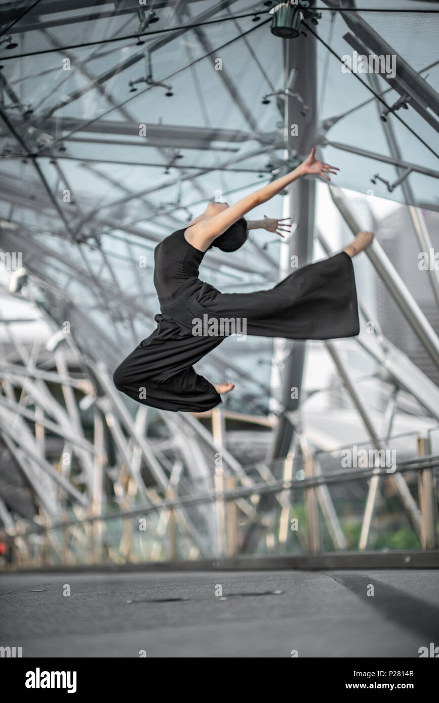Beautiful Young Girl Dancing on a bridge, wearing black Stock Photo - Alamy