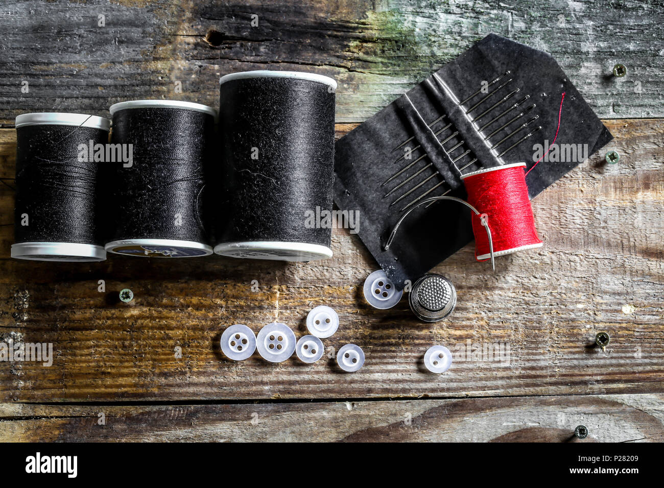 set of sewing threads and accessories on wooden background contrast ...