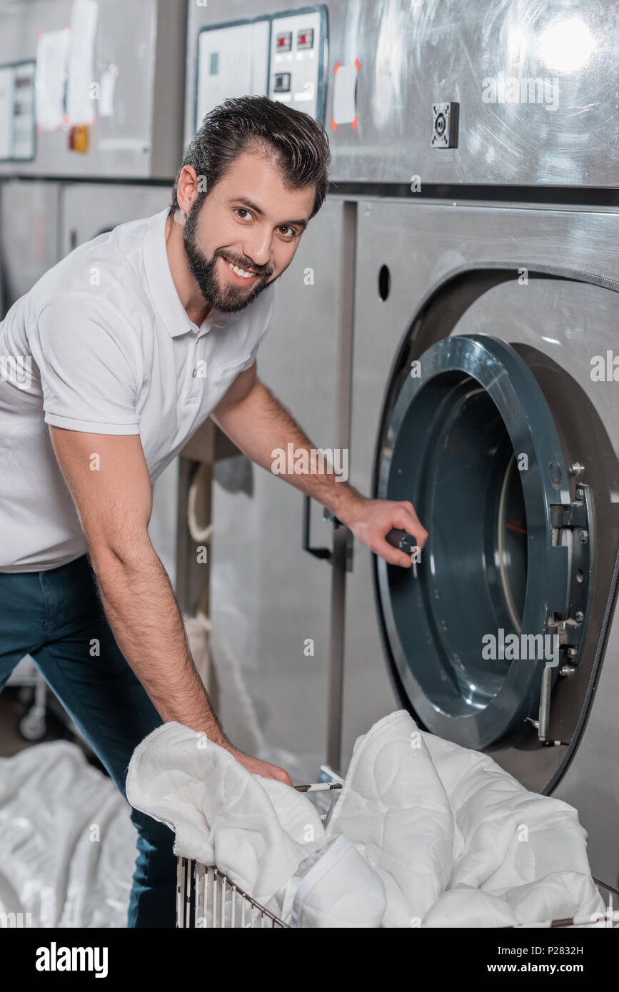 dry cleaning worker opening industrial washing machine Stock Photo - Alamy