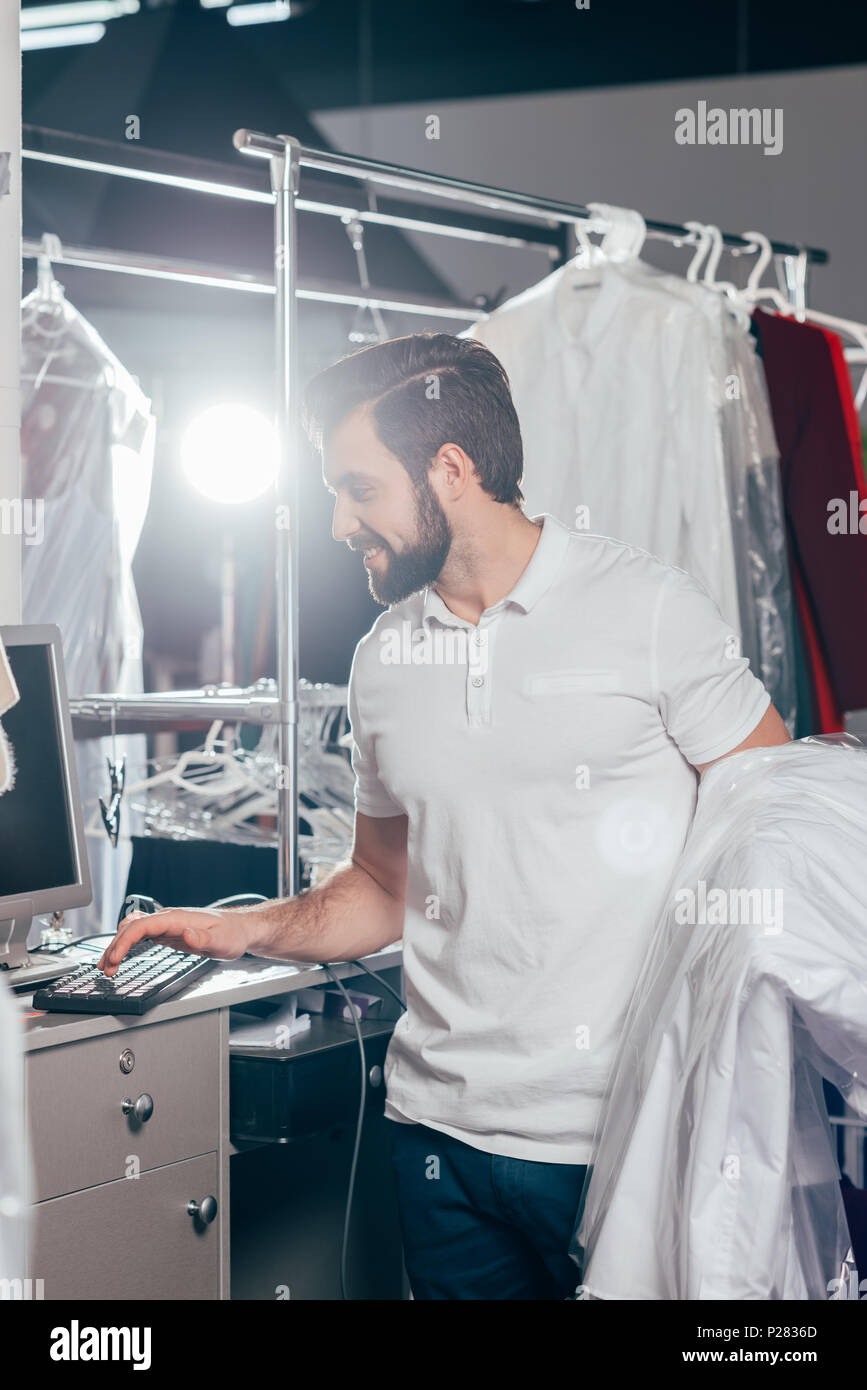 dry cleaning worker using computer at warehouse Stock Photo - Alamy