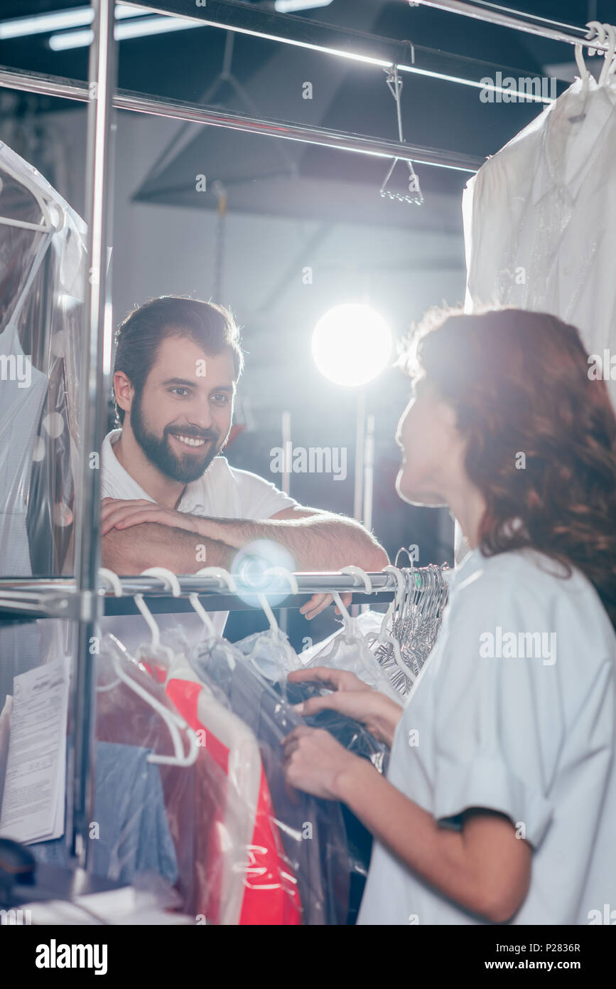 young dry cleaning workers talking at warehouse Stock Photo - Alamy