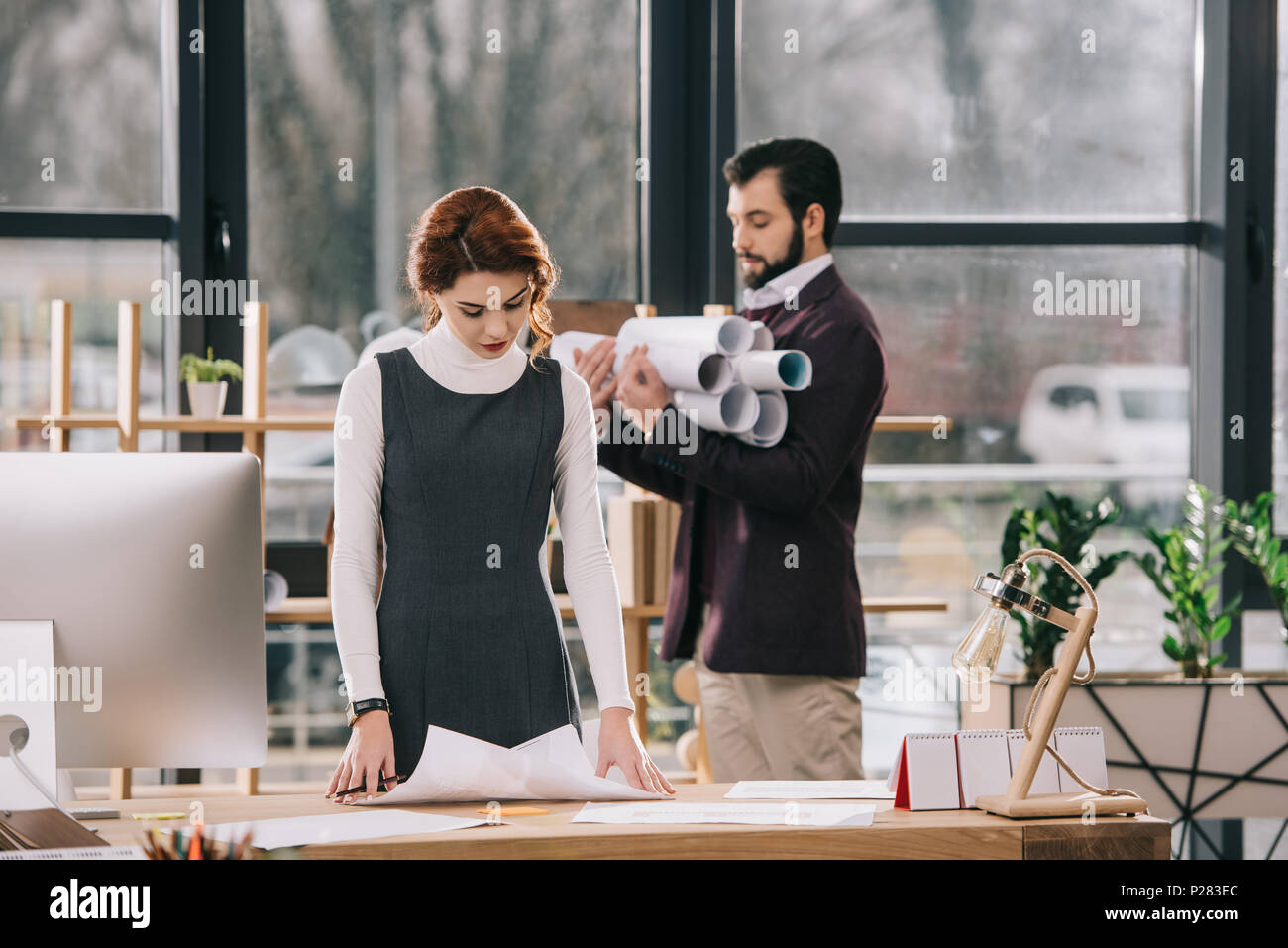 two architects working with blueprints in modern office Stock Photo - Alamy