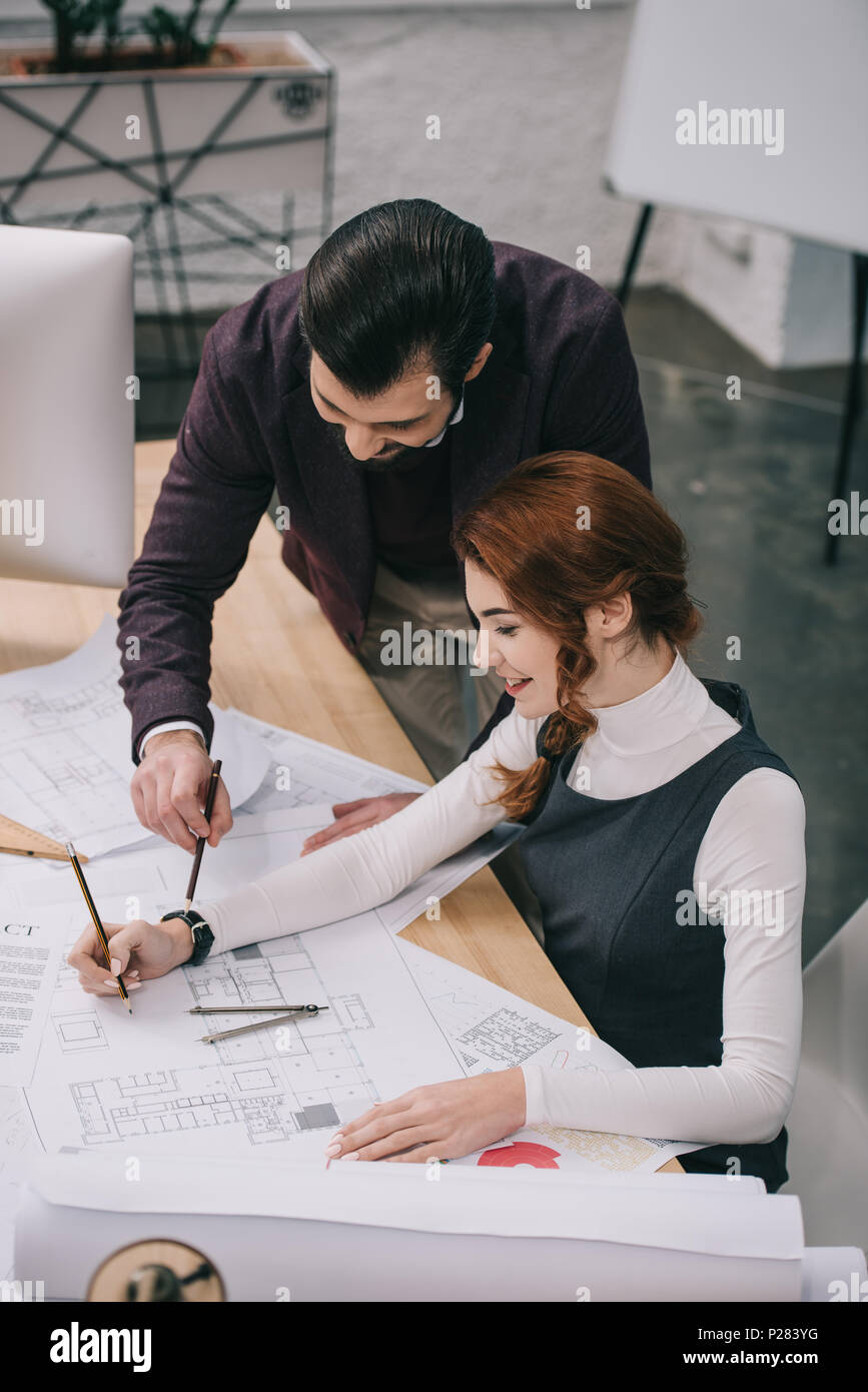 architects working with blueprints at workplace in modern office Stock ...
