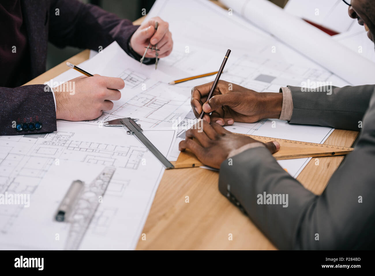 cropped shot of architects drawing architectural plans together Stock ...