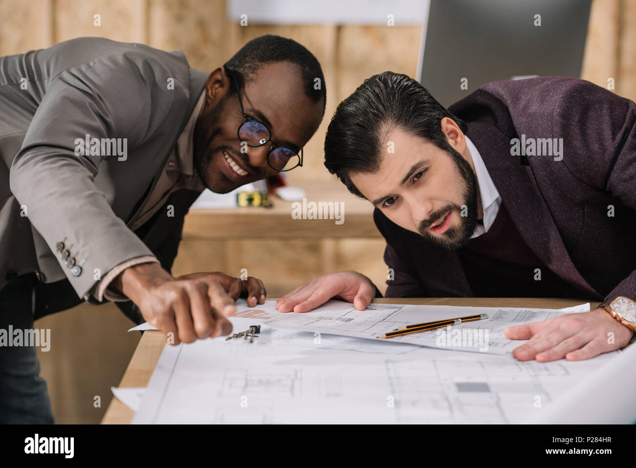 young multiethnic architects discussing building plans Stock Photo - Alamy