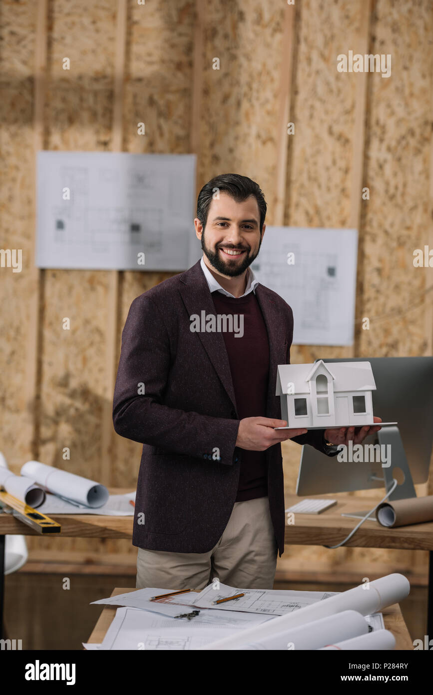 young architect with paper house model in office Stock Photo - Alamy