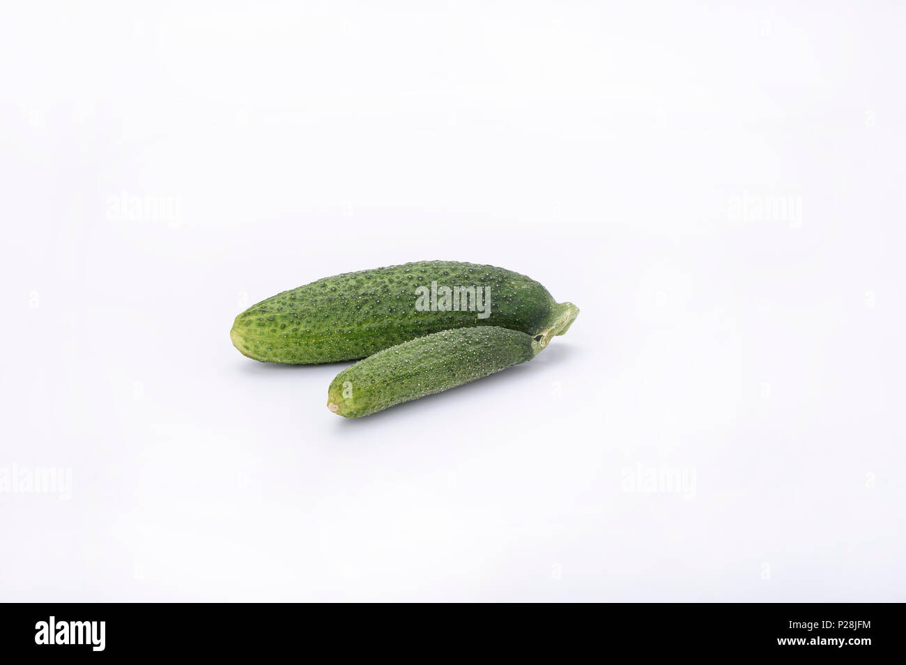 Two fresh cucumbers fastened together isolated on white Stock Photo - Alamy