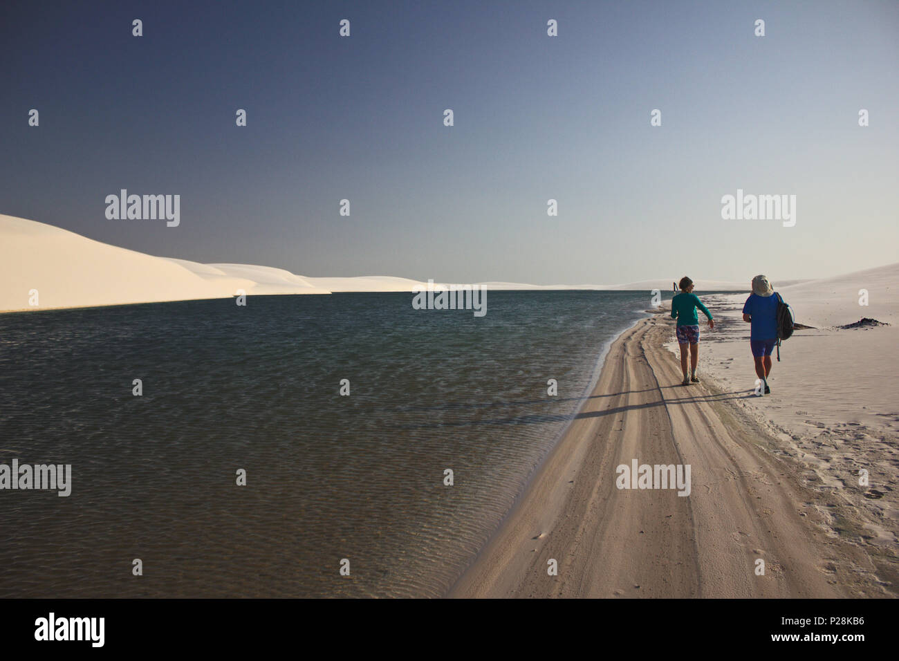 couple walks along a fresh water lagoon surrounded by sand dunes Stock ...